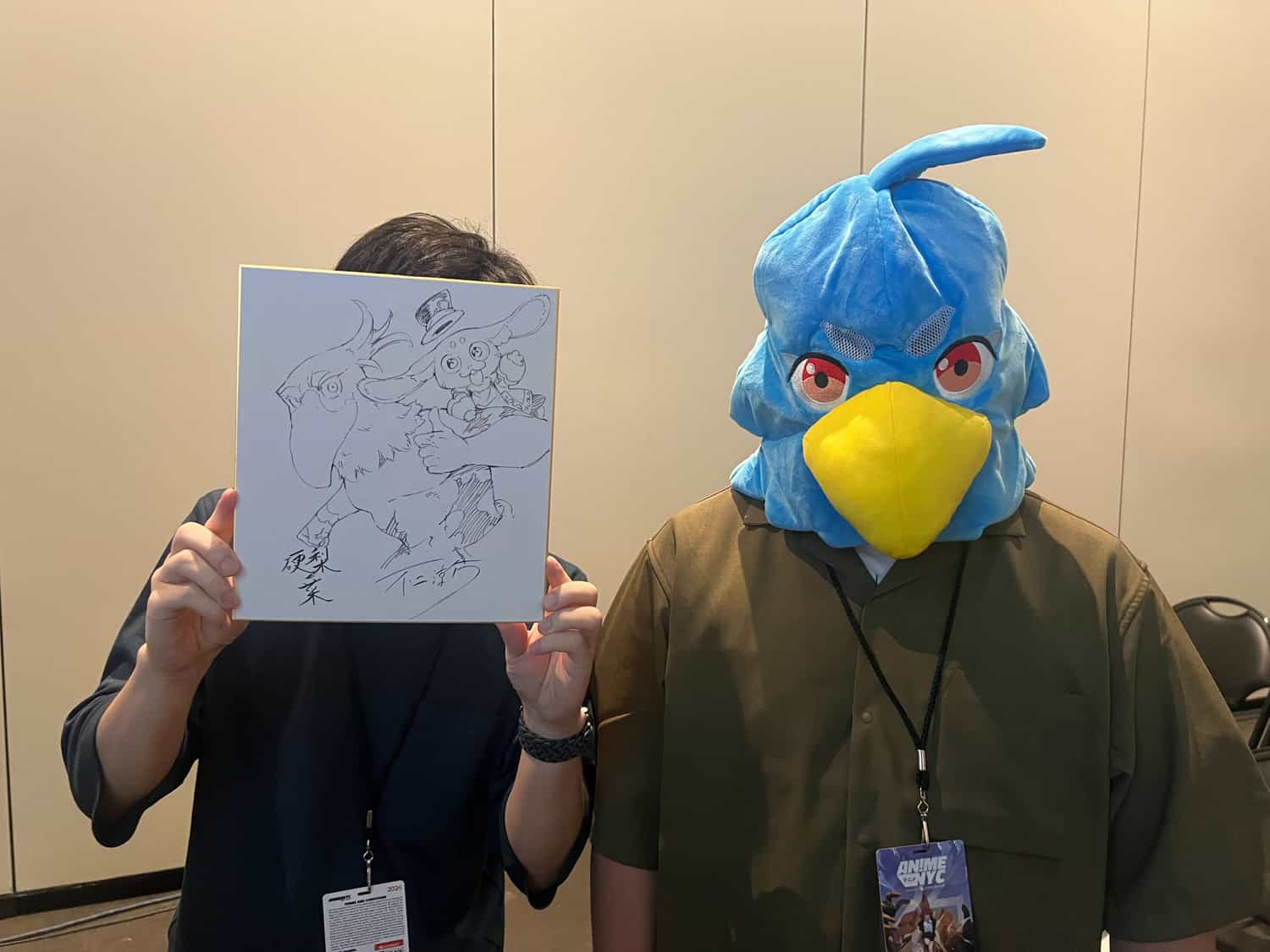 Shangri-La Frontier manga creators Katarina and Ryosuke Fuji displaying final giveaway art piece.